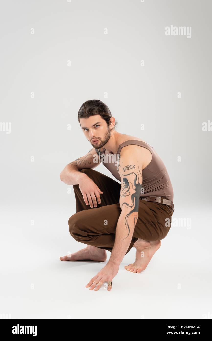 Young shirtless muscular caucasian man, posing on a beach on a warm ...