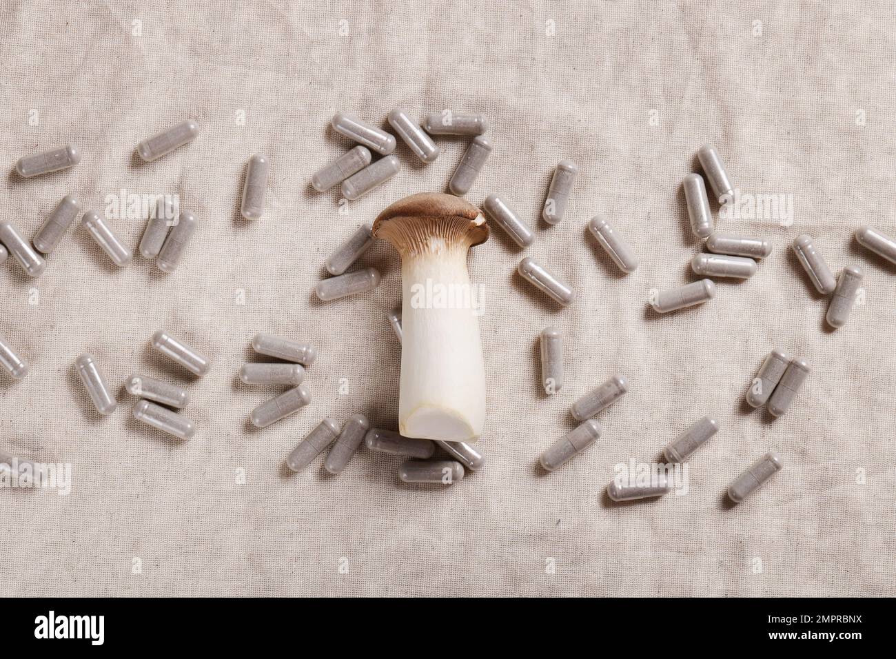 mushroom and natural herbal pills on textile gray background ...