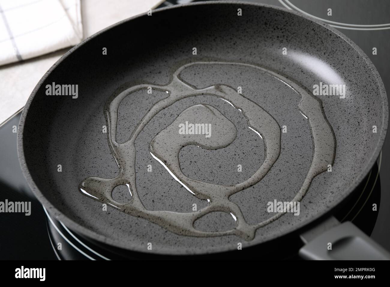 Frying pan with cooking oil on induction stove Stock Photo - Alamy