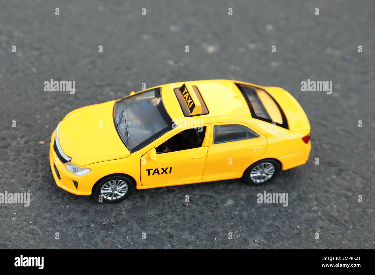 Yellow taxi car model on city street Stock Photo - Alamy