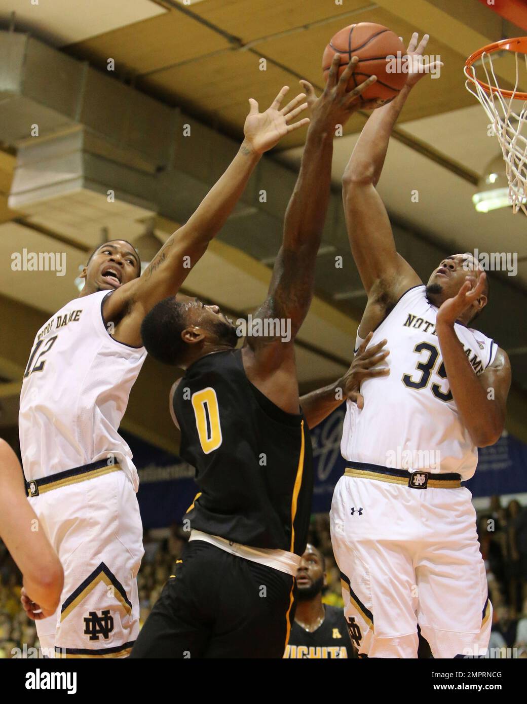 Notre Dame forwards Elijah Burns (12) and Bonzie Colson (35) defend ...
