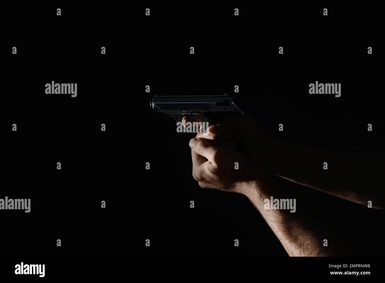 Professional killer with gun on black background, closeup Stock Photo ...