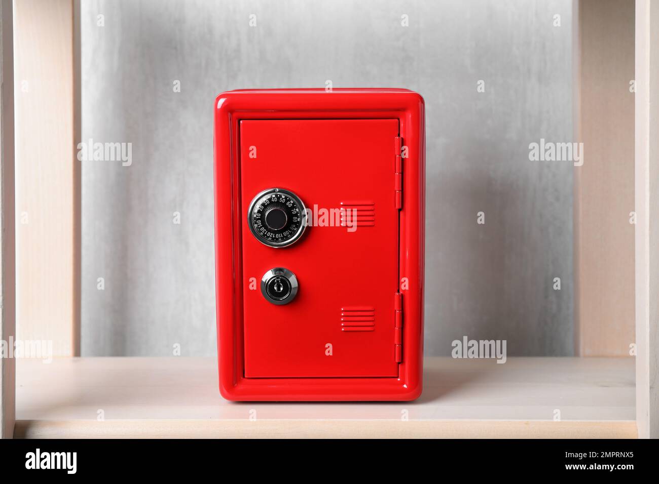 Red steel safe with mechanical combination lock on shelf Stock Photo ...