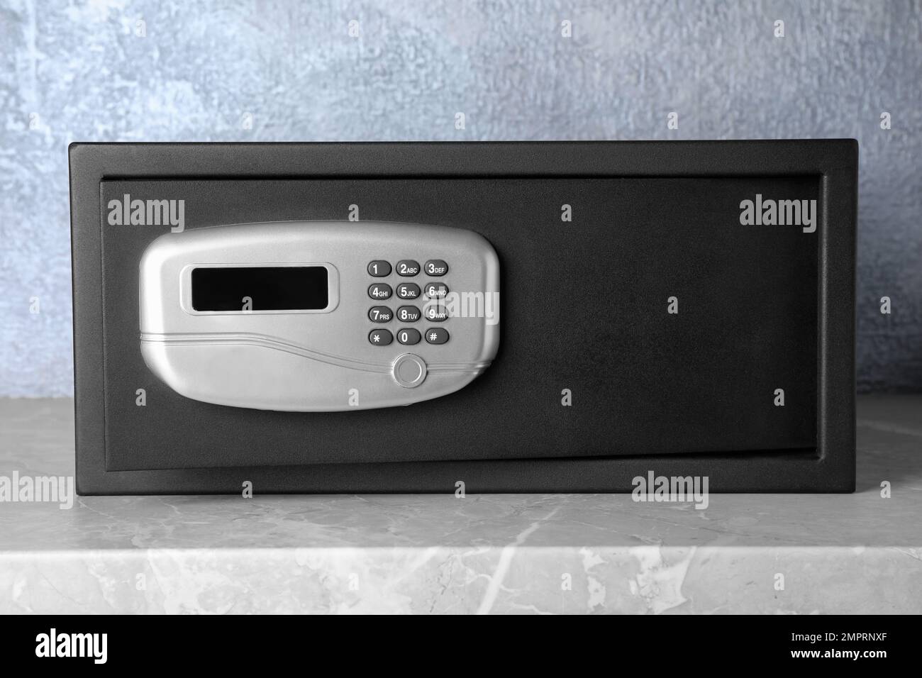 Black steel safe with electronic lock on grey marble table Stock Photo ...