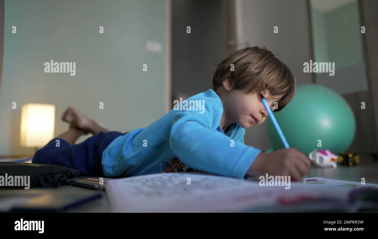 One Concentrated child doing school homework activity in bedroom ...