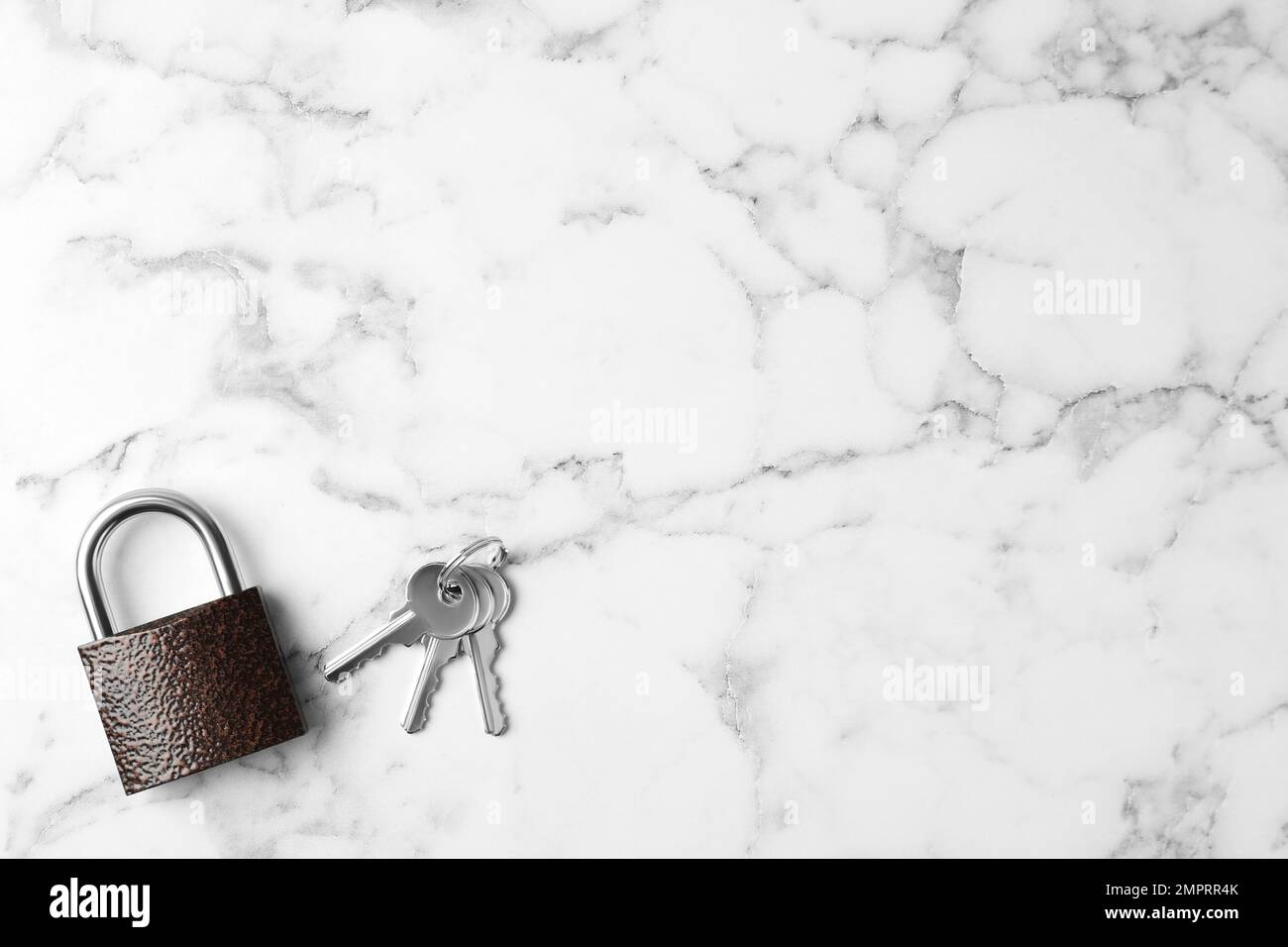 Steel padlock, keys and space for text on white marble background, top ...