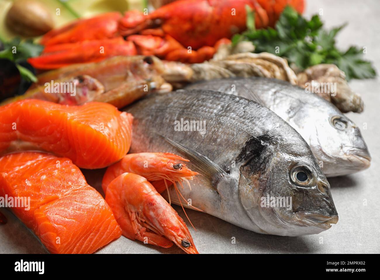 Fresh fish and different seafood on light grey table, closeup Stock ...