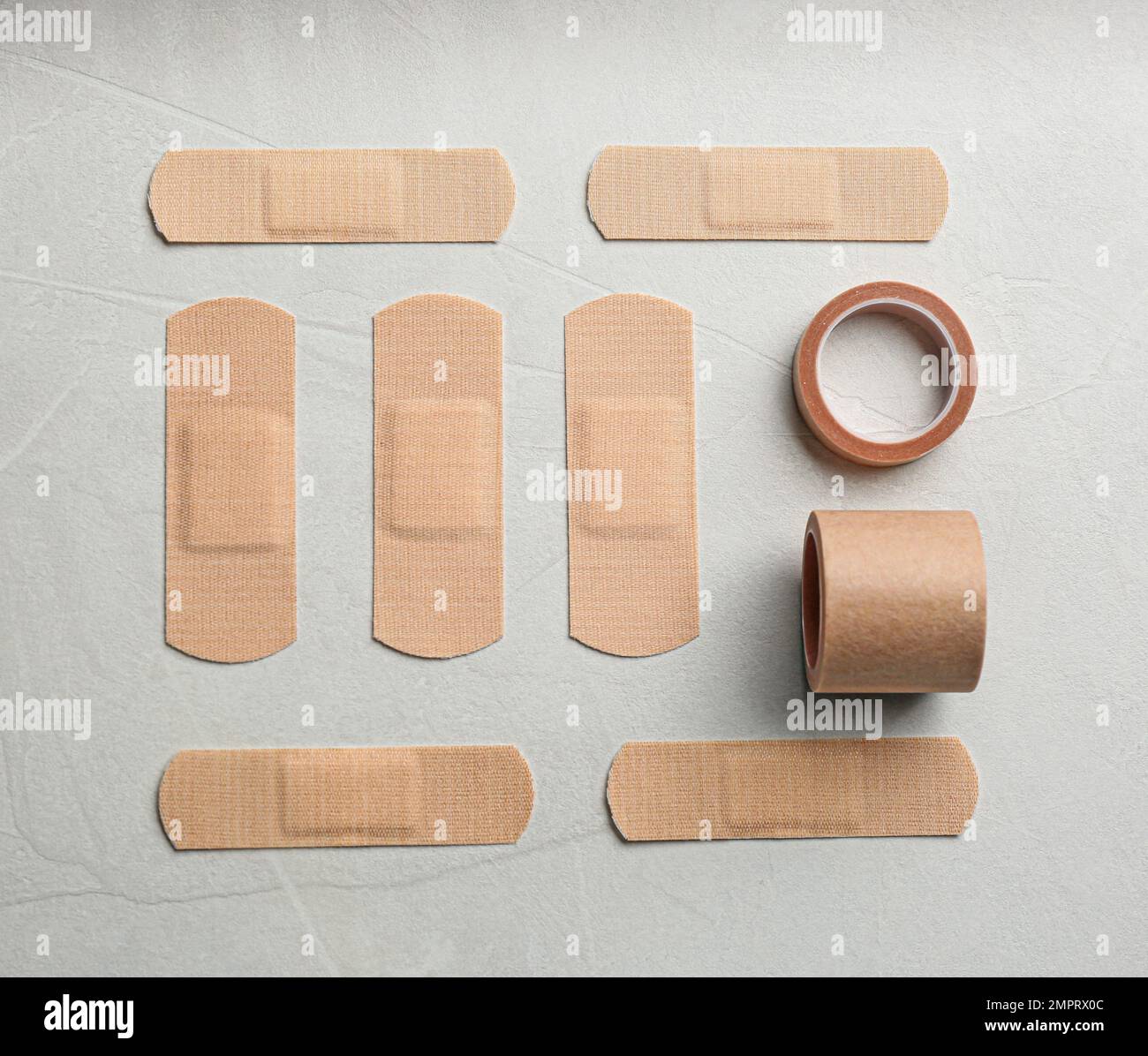 Different types of sticking plasters on light stone background, flat ...