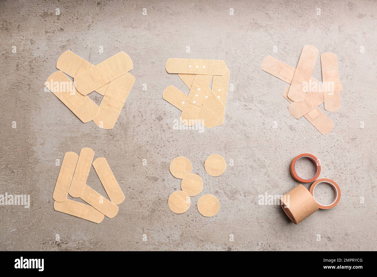 Different types of sticking plasters on stone background, flat lay ...