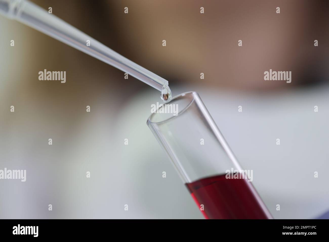 Laboratory diagnostic doctor dripping drop of liquid into test tube ...