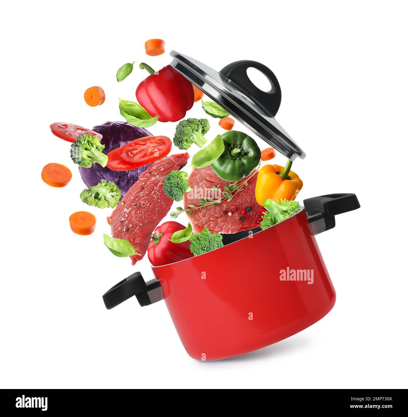 Many different ingredients falling into pot on white background Stock ...