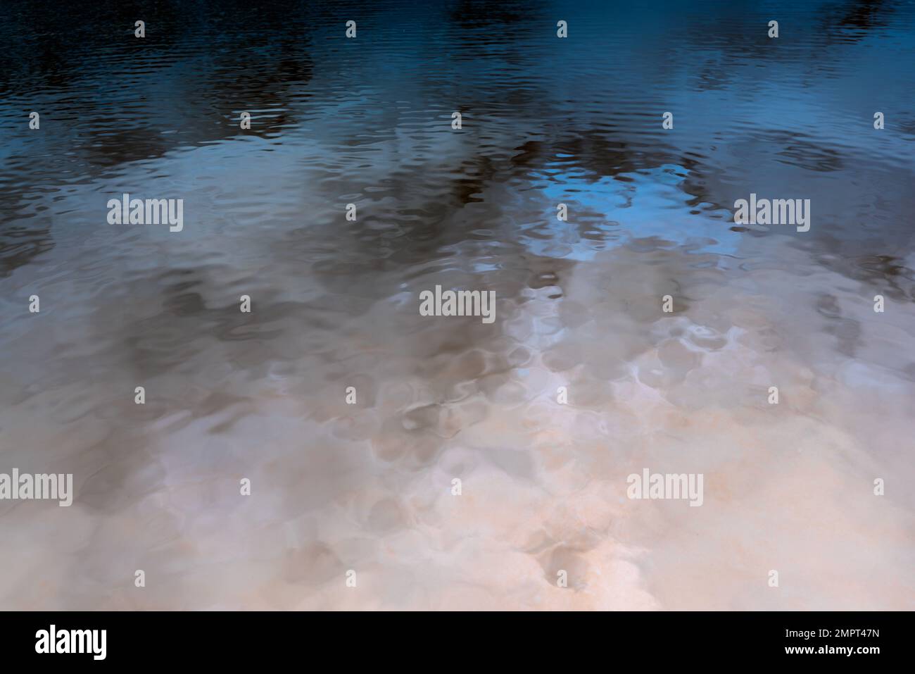 Abstract photo of water surface with reflection of clouds and sky ...