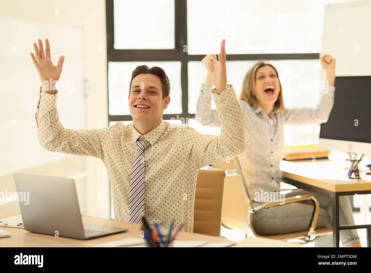 Business partners rejoicing and raising their hands up in office Stock ...