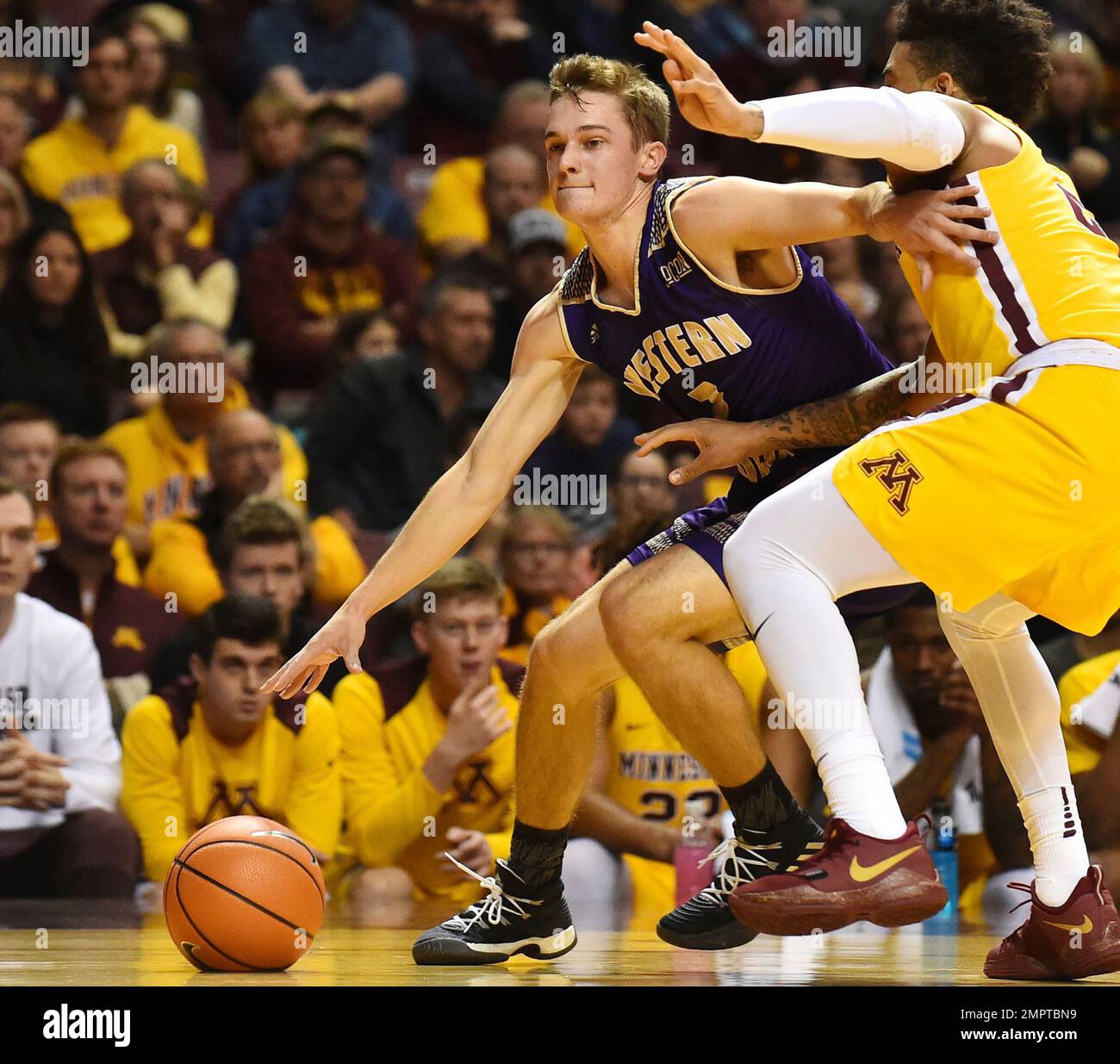 Western Carolina guard Matt Halvorsen fights off Minnesota guard Nate ...