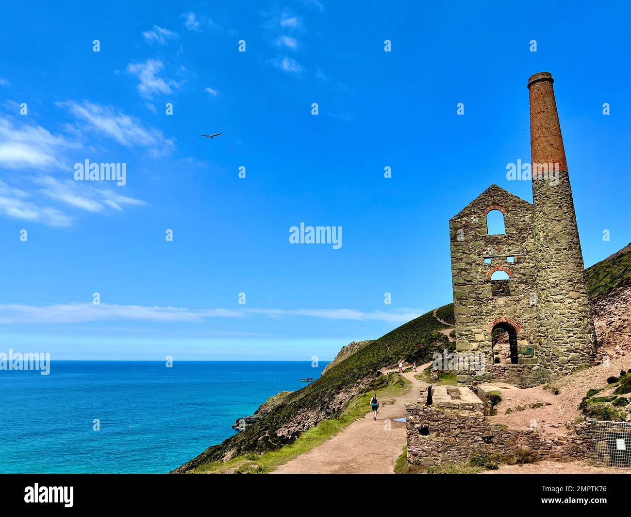 The ruins of the Cornish tin mine building with the blue sky and sea in ...