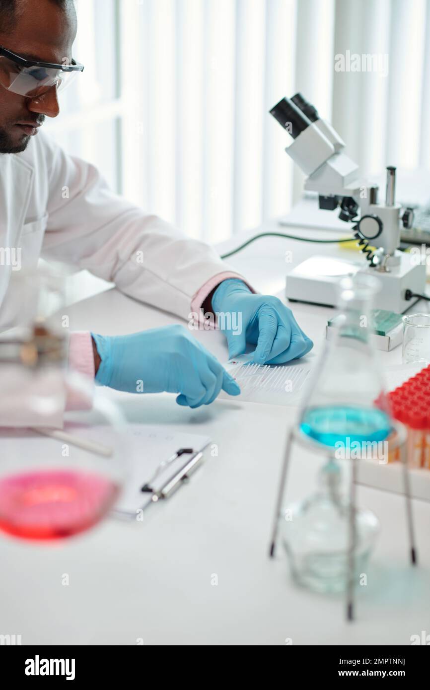 Laboratory worker checking blood of patient for diseases and viruses ...