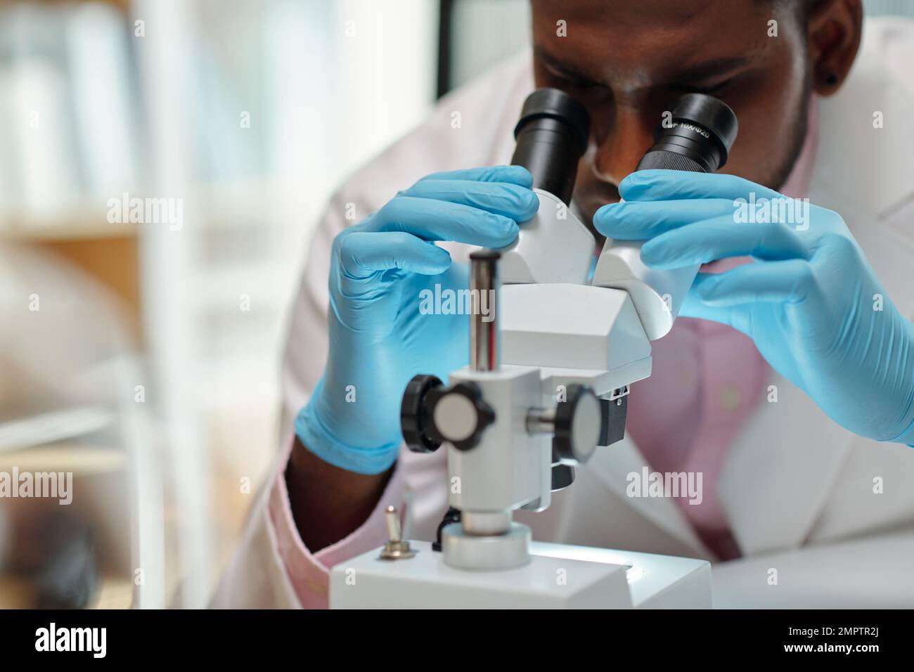 Black man looking through microscope hi-res stock photography and ...