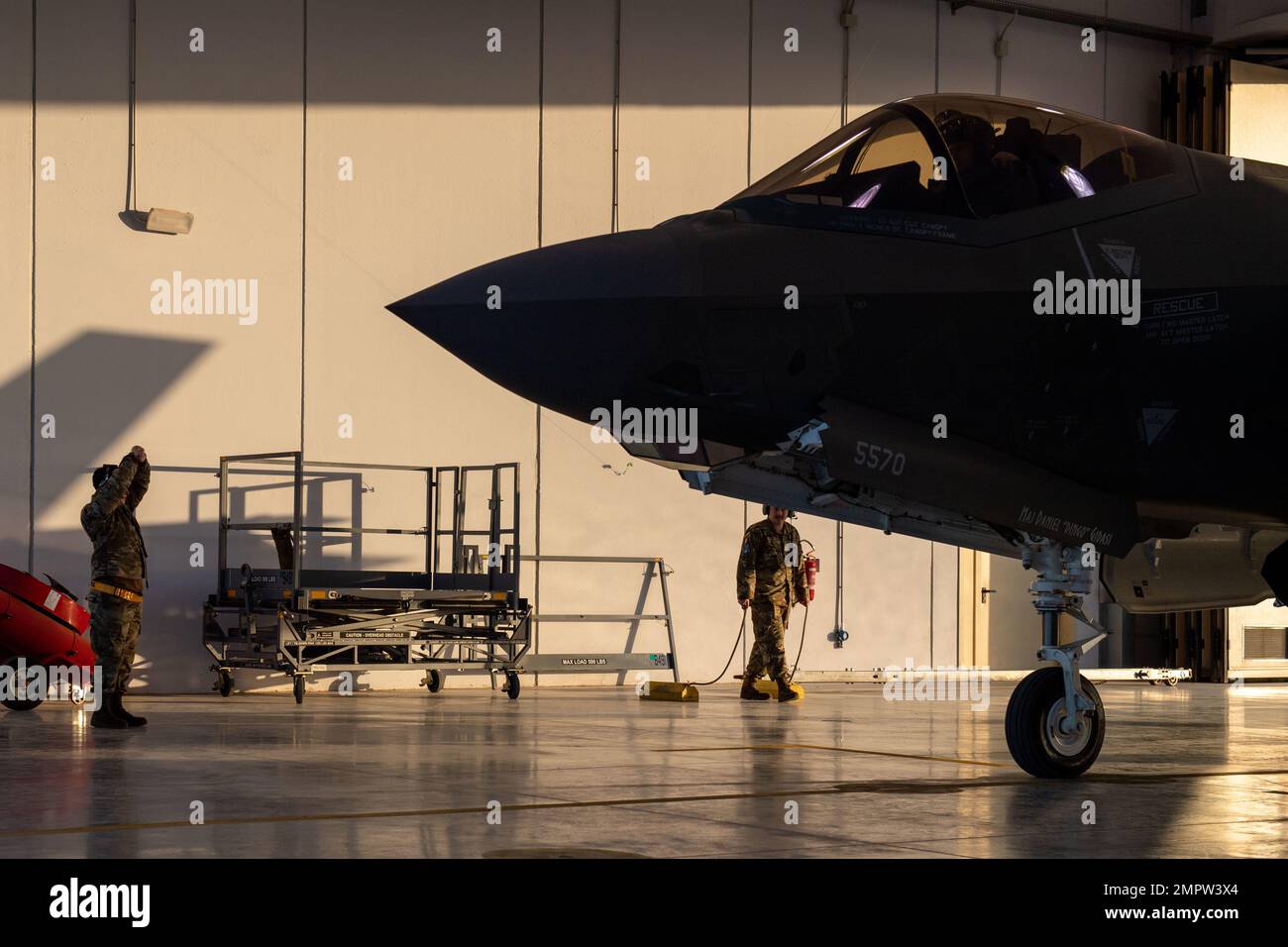 A U.S. Air Force Airman marshals an F-35 Lightning II back into its ...