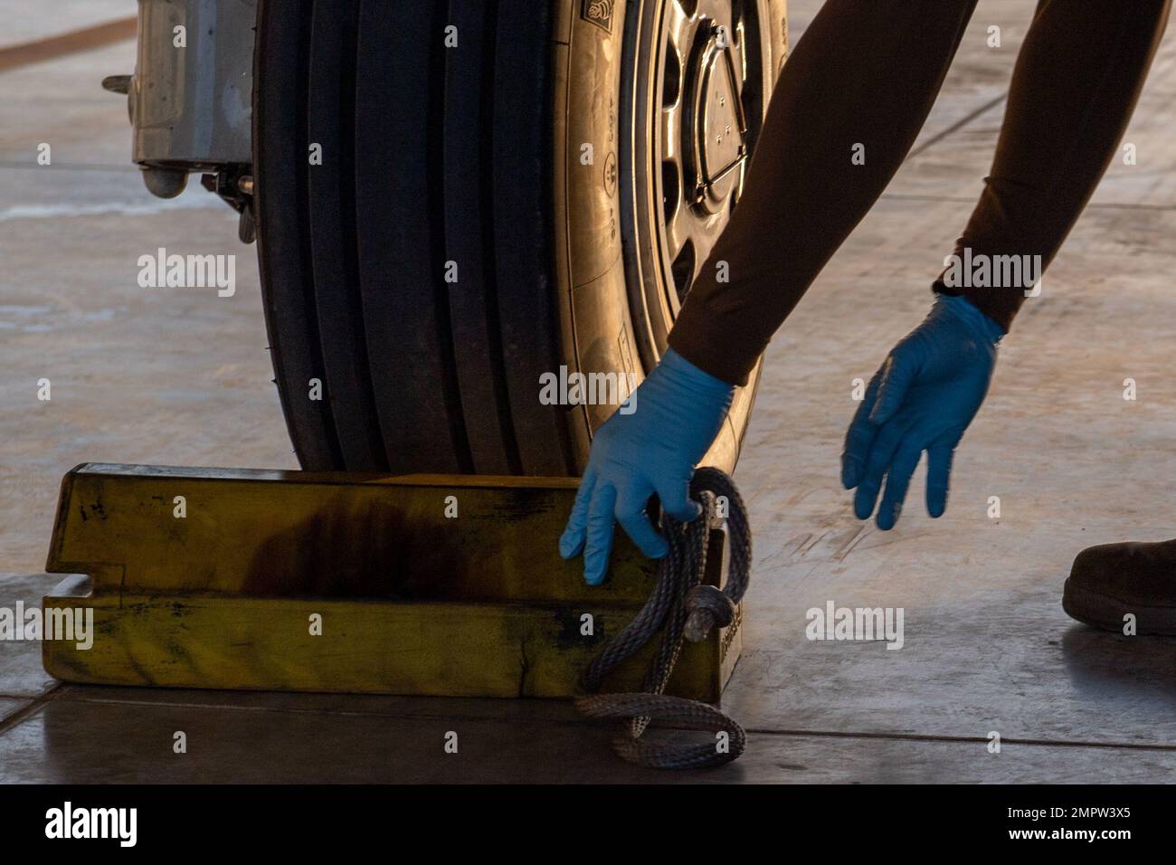 A U.S. Air Force Airman applies parking chocks to an F-35 Lightning II ...