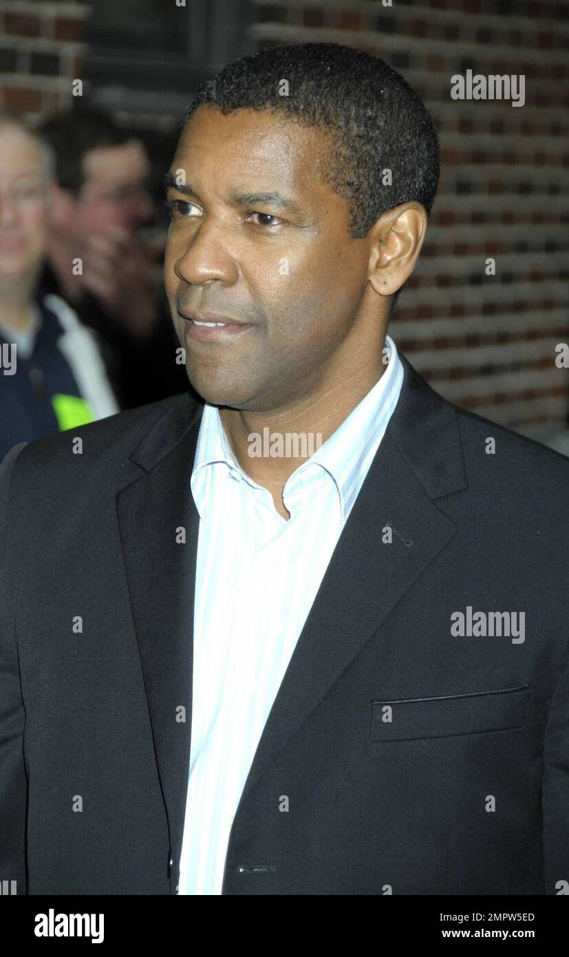 Denzel Washington is helped with putting on his jacket by his chauffeur ...