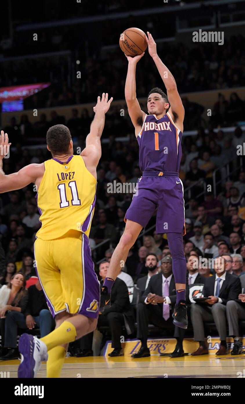 Phoenix Suns guard Devin Booker, right, shoots as Los Angeles Lakers ...