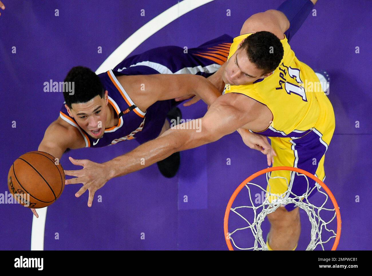 Phoenix Suns guard Devin Booker, left, shoots as Los Angeles Lakers ...