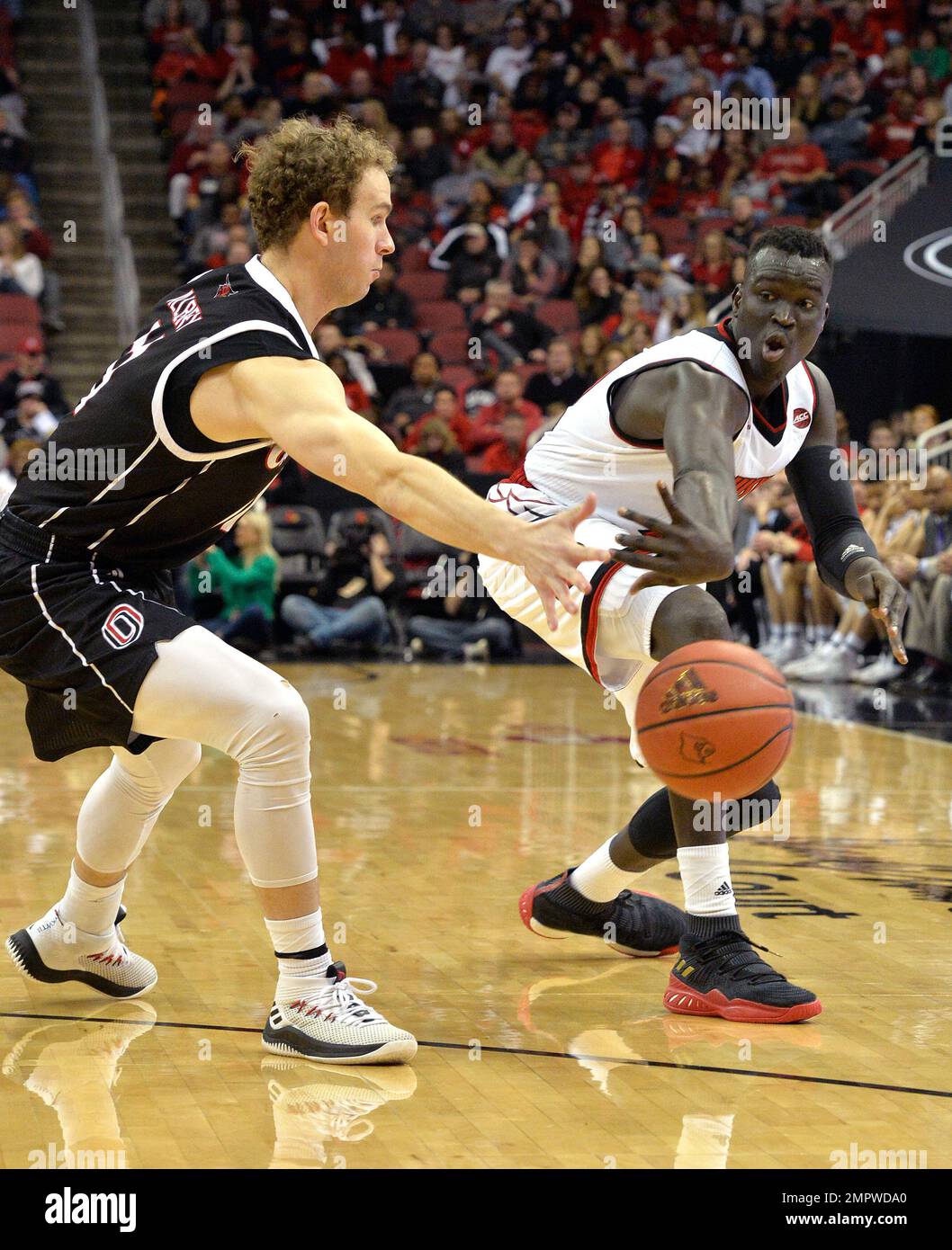 Louisville forward Deng Adel (22) passes the ball away from the defense ...