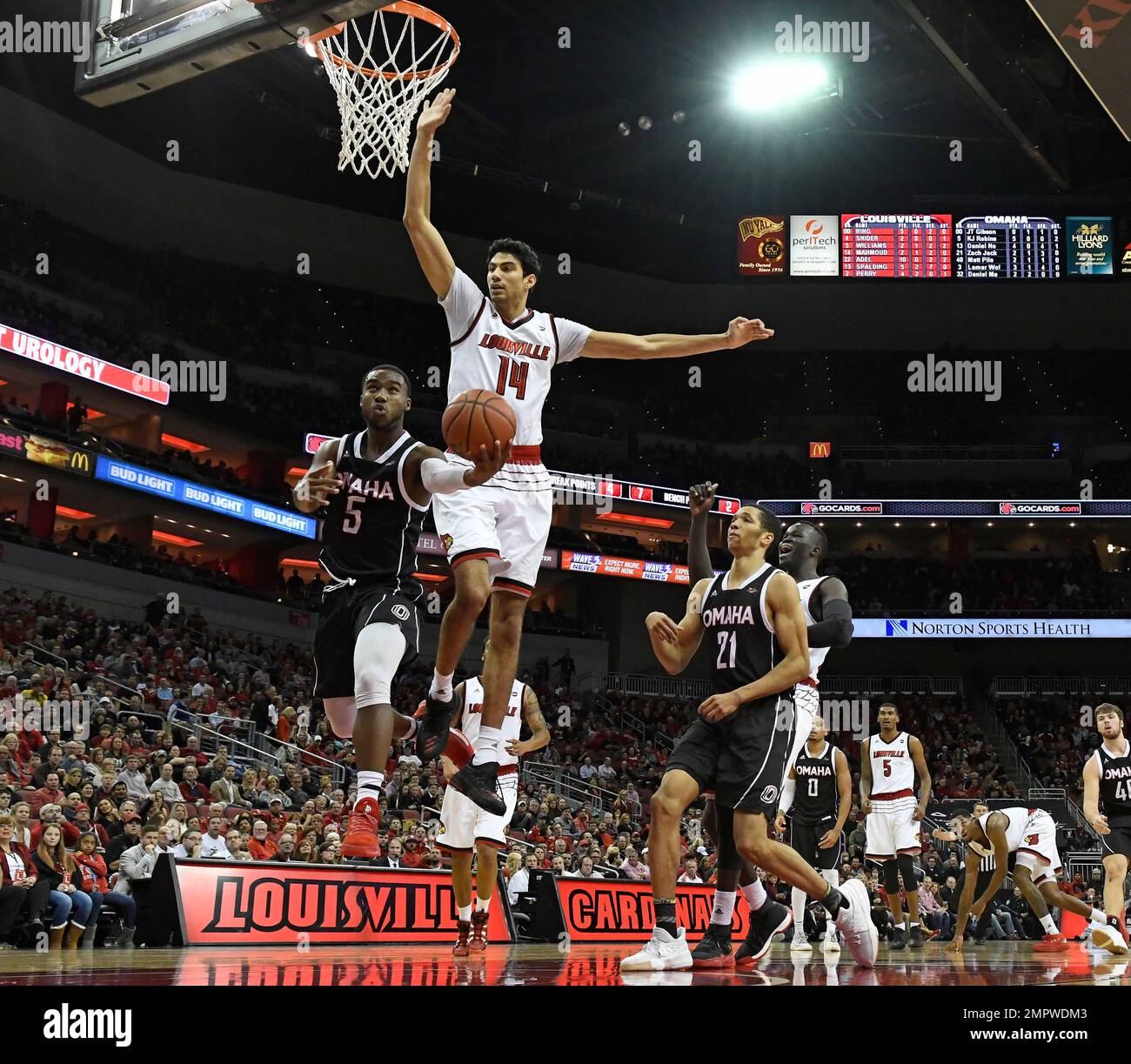 Omaha guard KJ Robinson (5) attempts a layup past the defense of ...