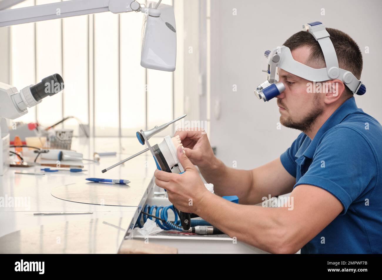 Dental technician working with articulator in dental laboratory. The ...