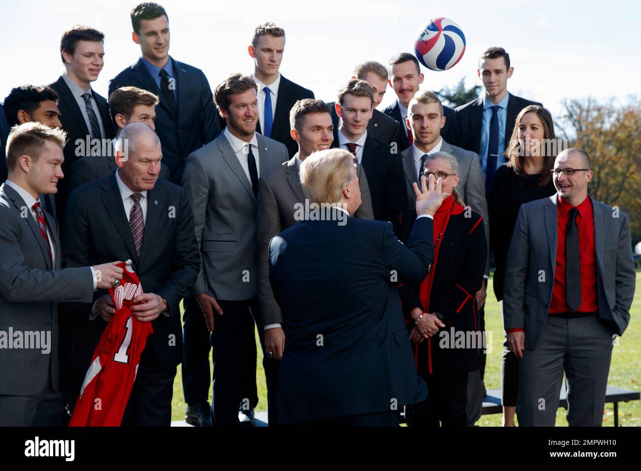 President Donald Trump tosses a volleyball into the air as he meets ...