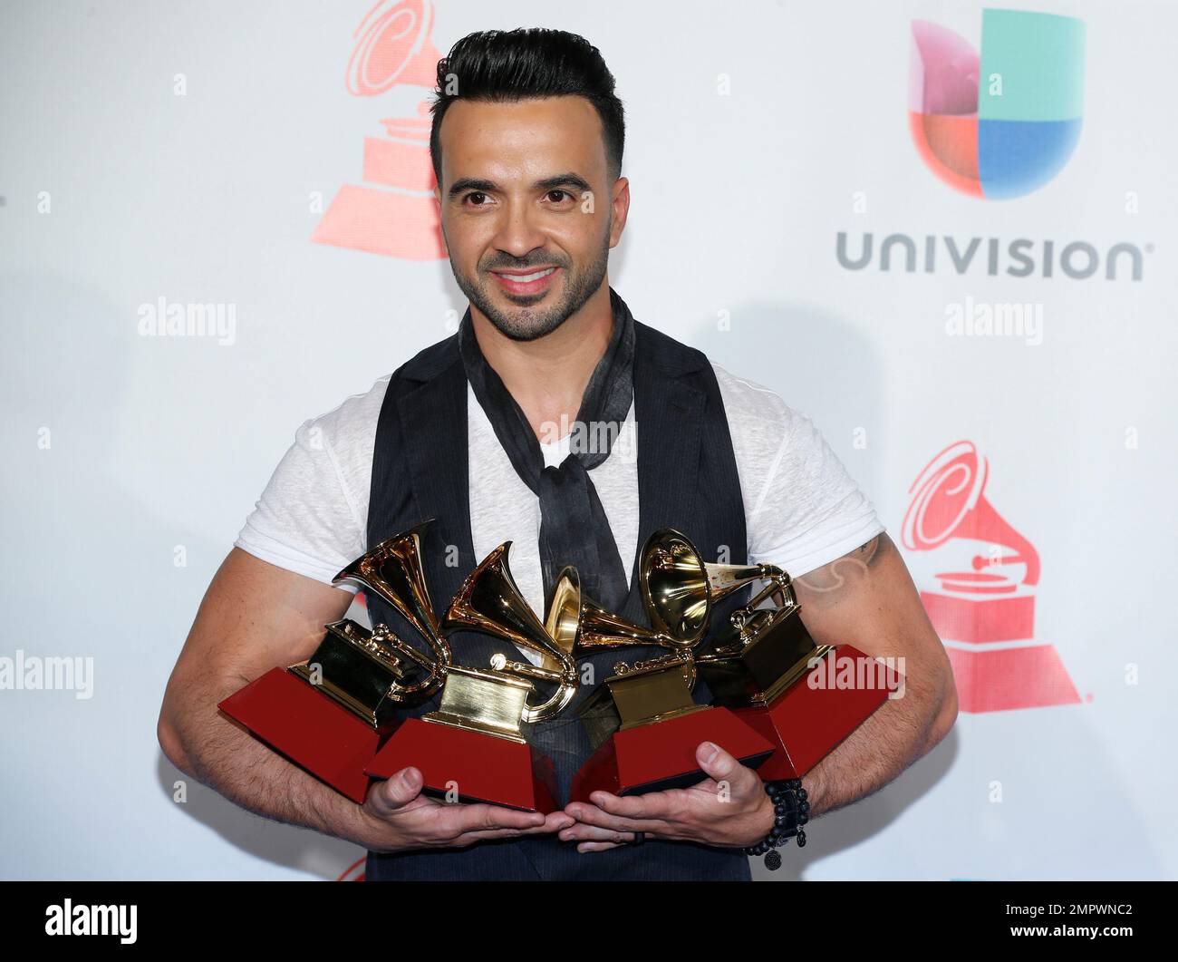 Luis Fonsi poses in the press room with the awards for best urban ...