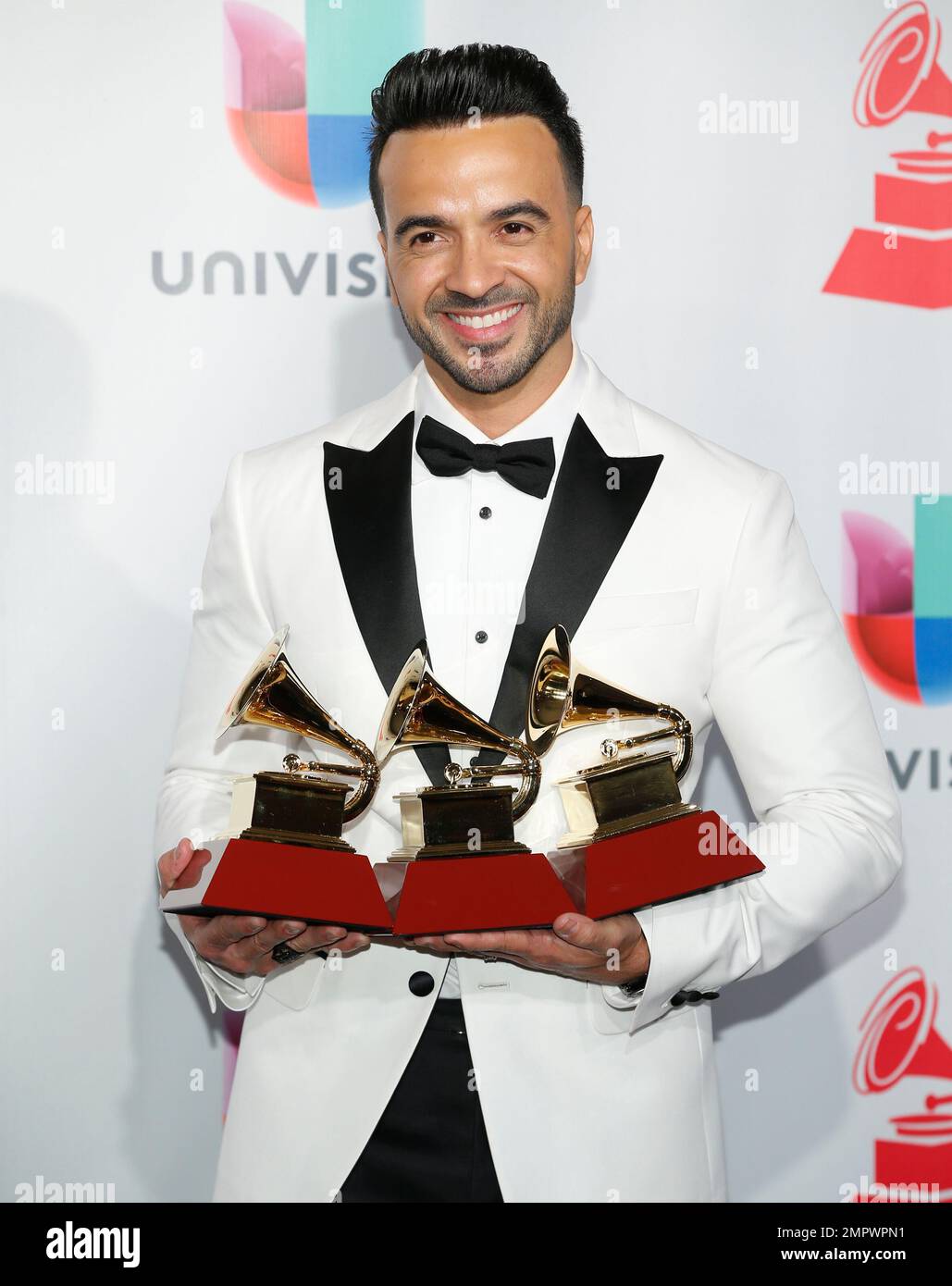 Luis Fonsi poses in the press room with the awards for best urban ...