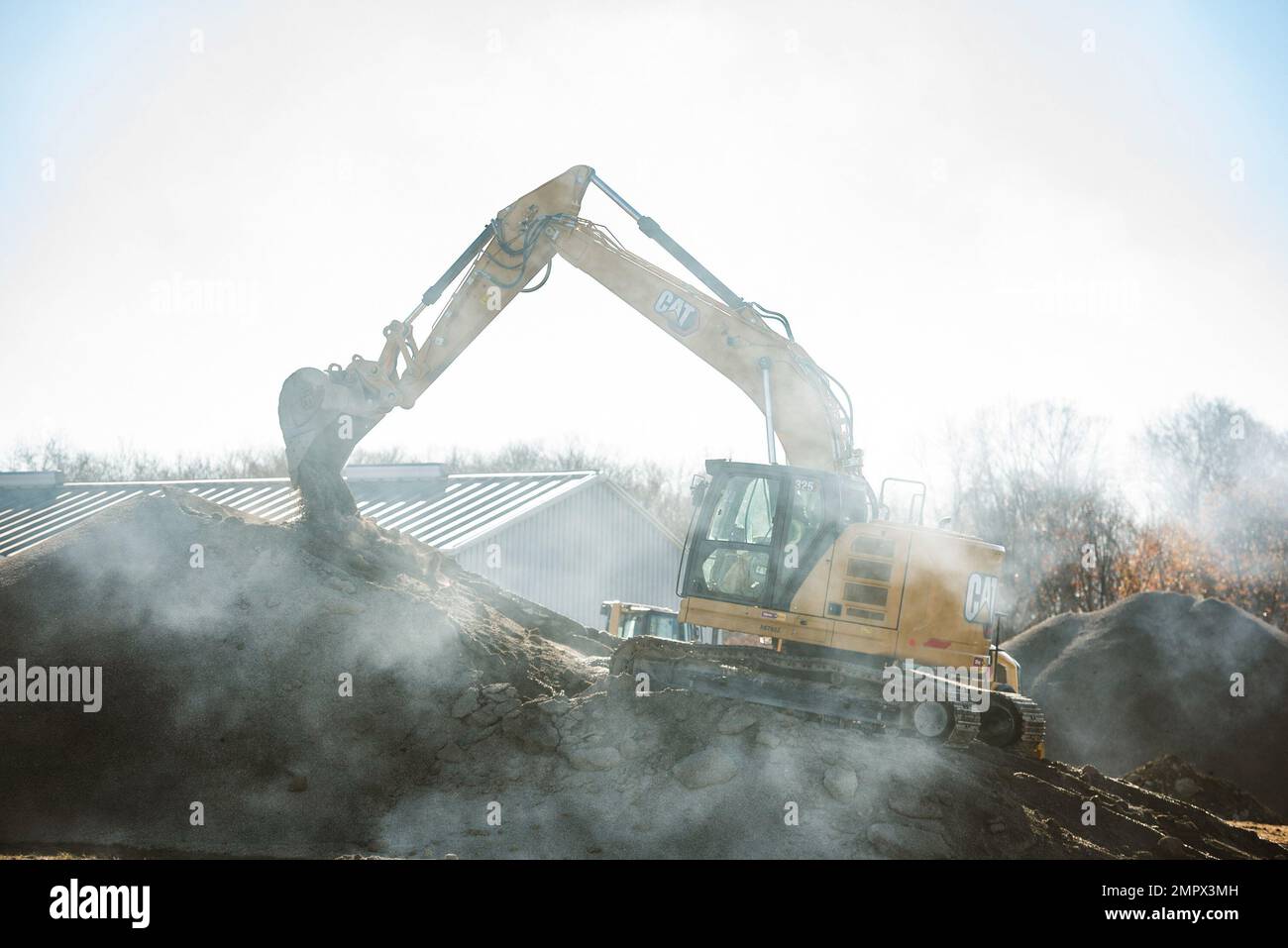 A worker uses an excavator Nov. 21 to prep a gravel pile at Wright ...