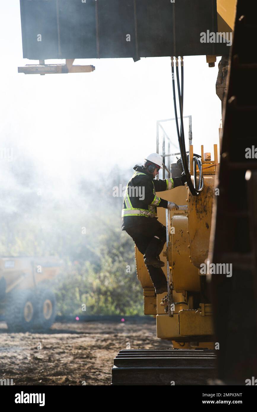 A DeWind construction worker climbs up the trencher Nov. 21 before ...