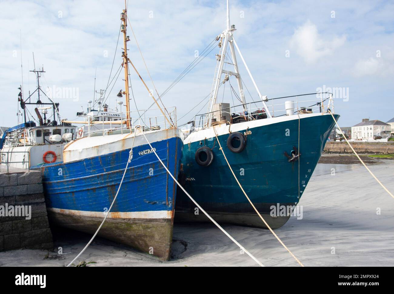 Two blue-coloured fishing boats alongside harbour quay in Ireland ...