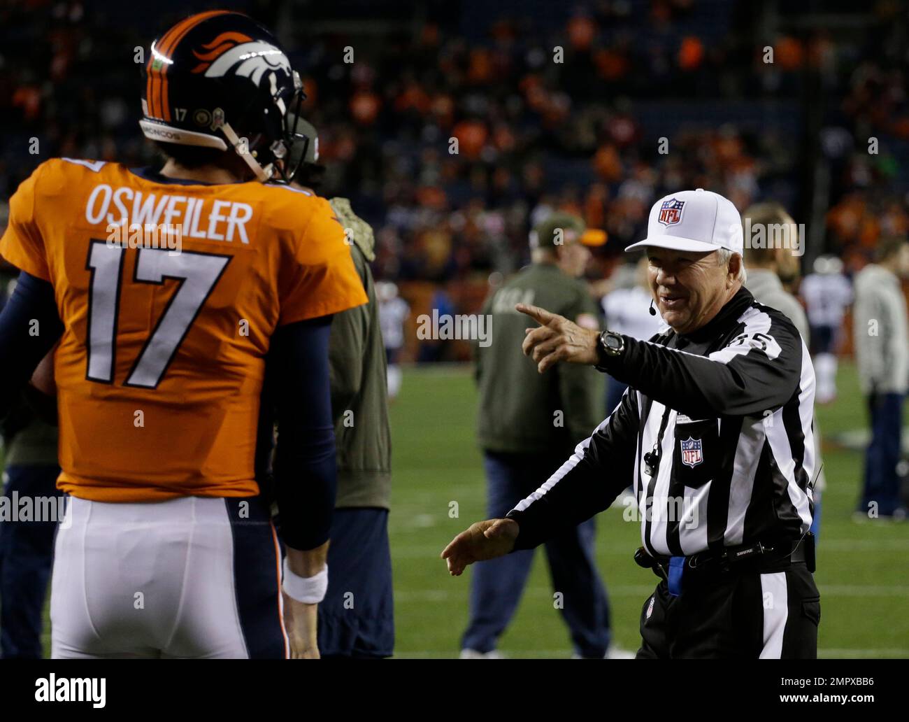 Side judge Alex Kemp (55) jokes with Denver Broncos quarterback Brock ...