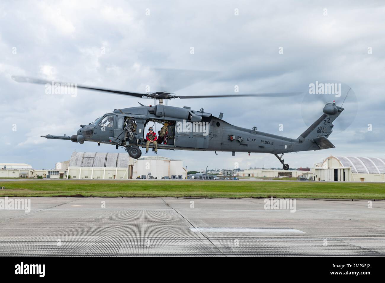 A 33rd Rescue Squadron HH-60 Pave Hawk hovers over a flight line in ...