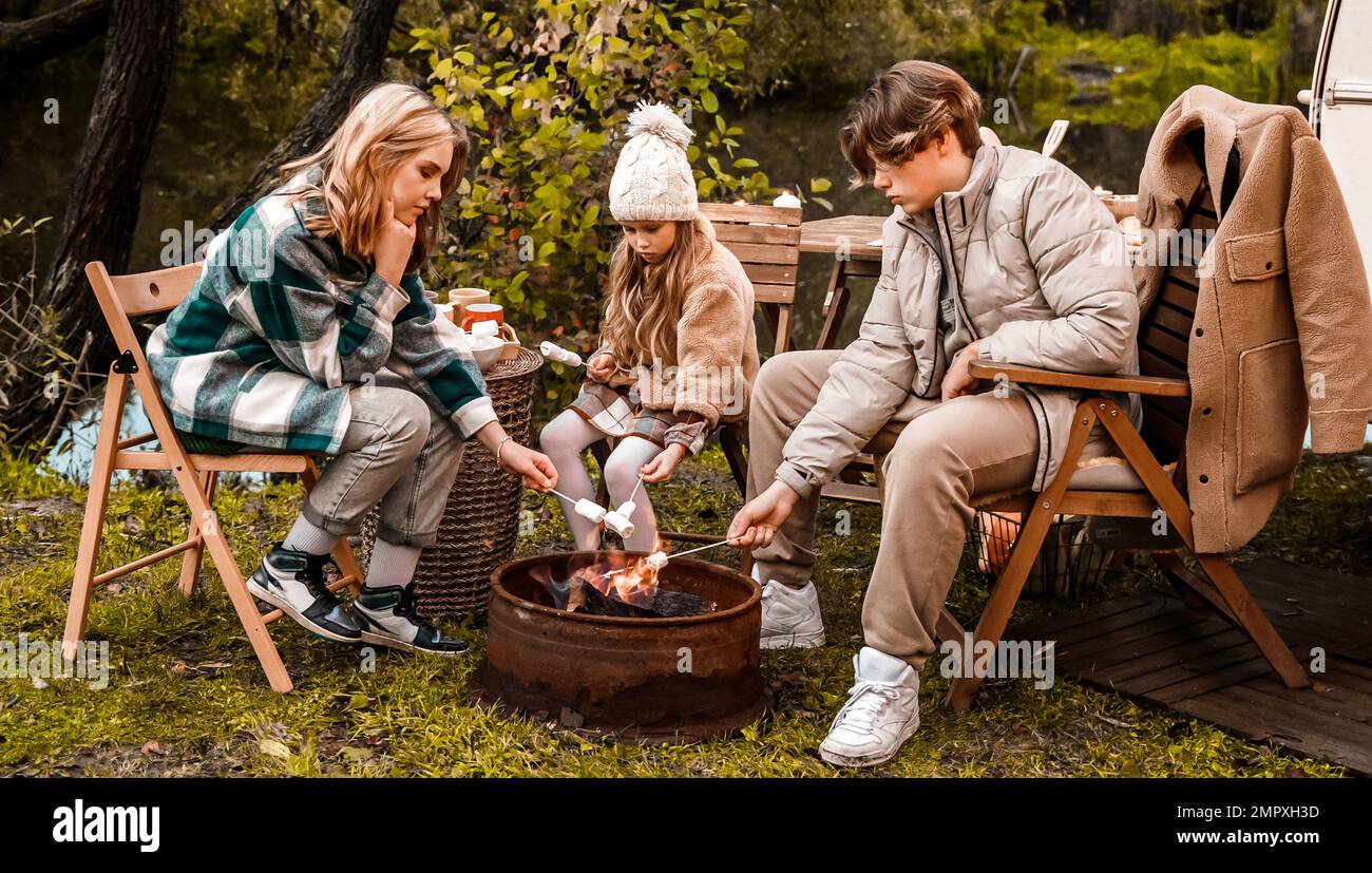 Children,family,brother sister fry marshmallows on fire. Picnic in ...