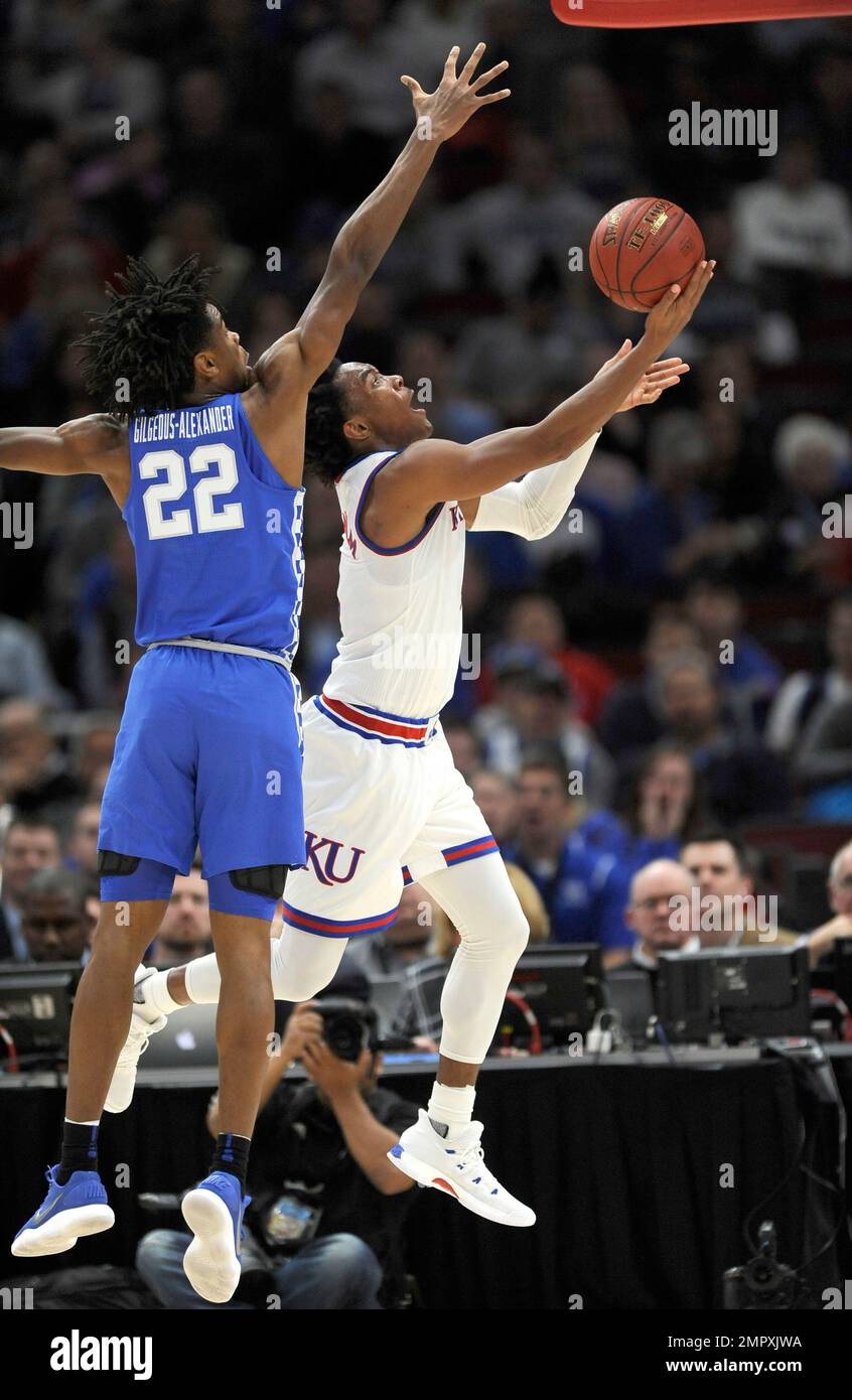 Kansas guard Devonte' Graham, right, drives past Kentucky guard Shai ...