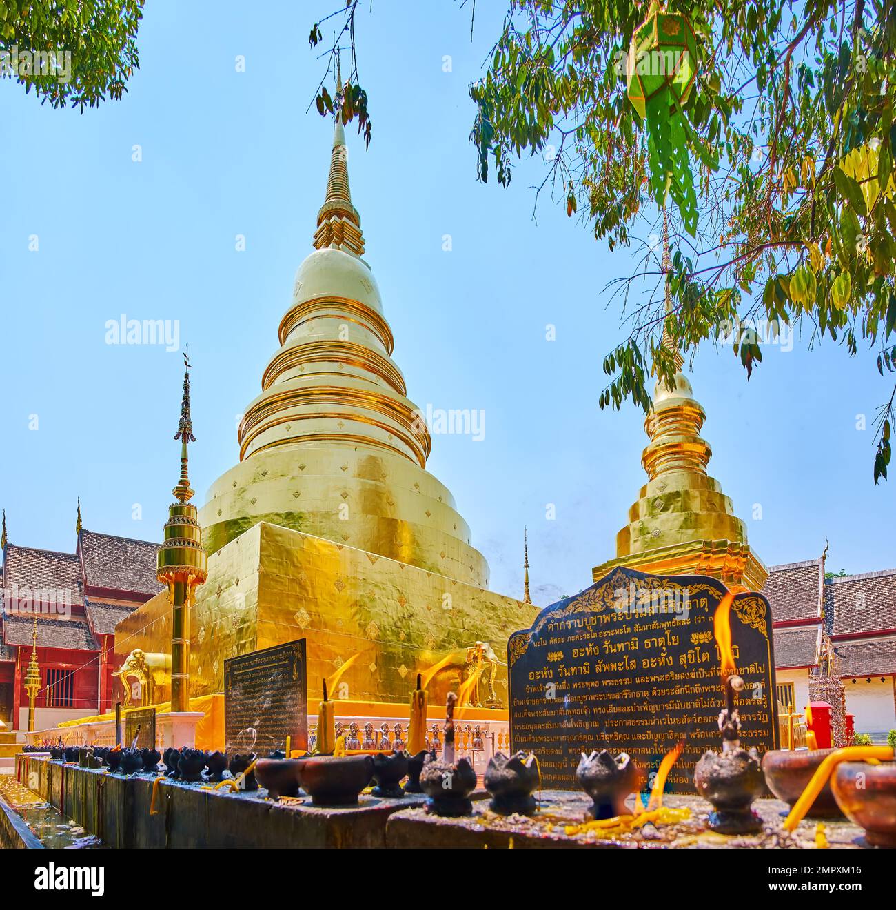 The altar with burning candles and incense sticks in front of Phra That ...