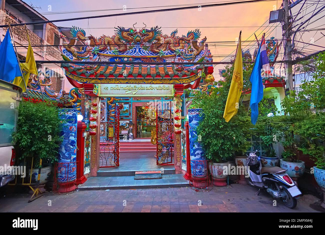 Ornate paifang gate of Pung Thao Kong Shrine with lush green plants in ...