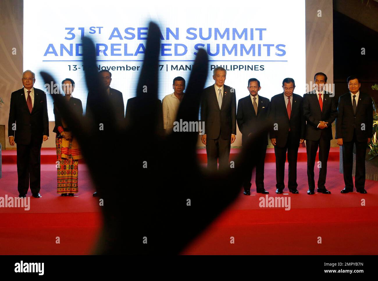 A photographer raises his hand to call the attention of ASEAN leaders ...