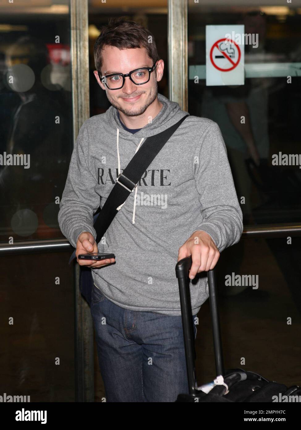 Elijah Wood arrives at heathrow airport all smiles for the camera ...