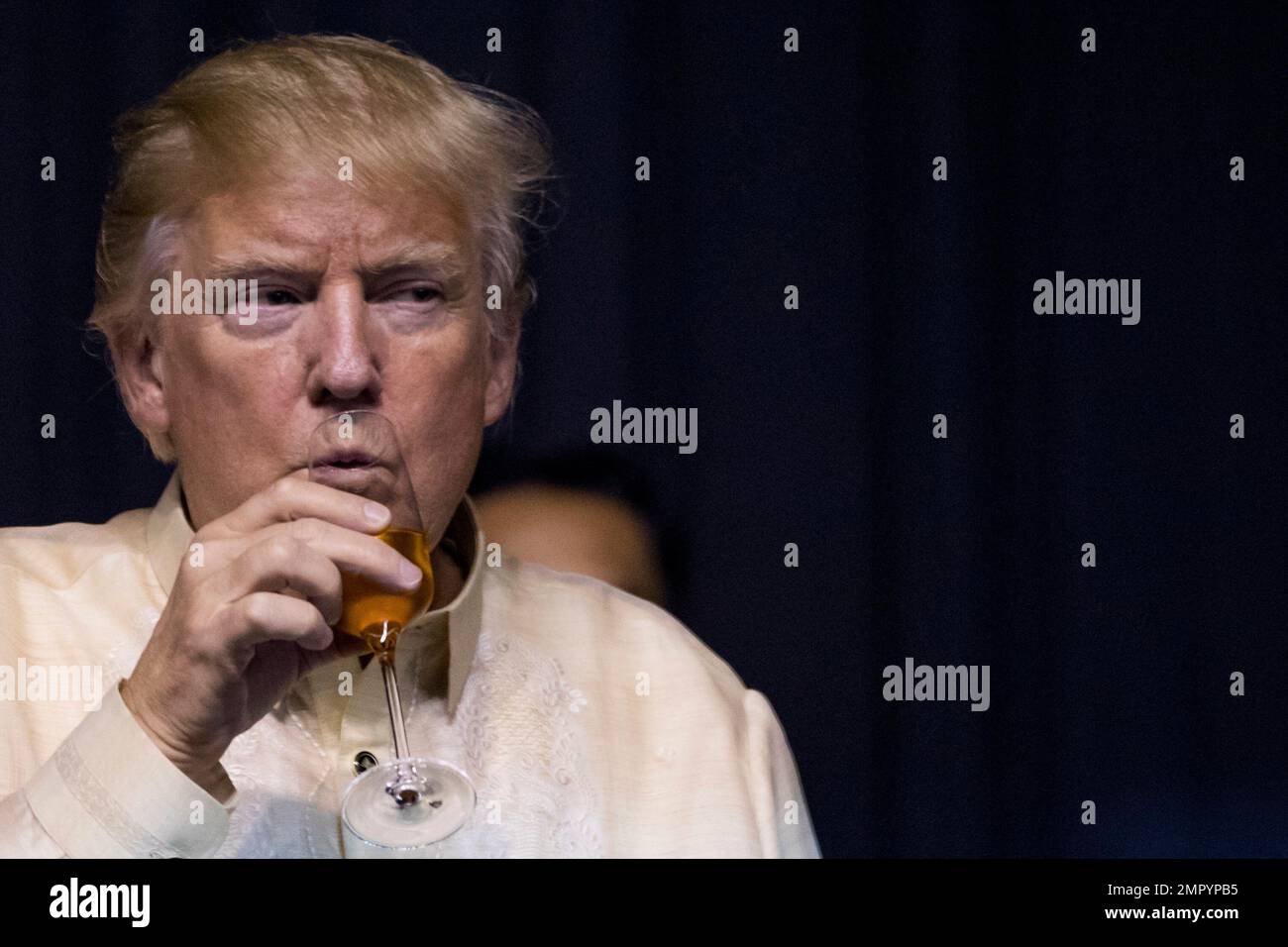 President Donald Trump takes a drink following a toast by Philippines ...