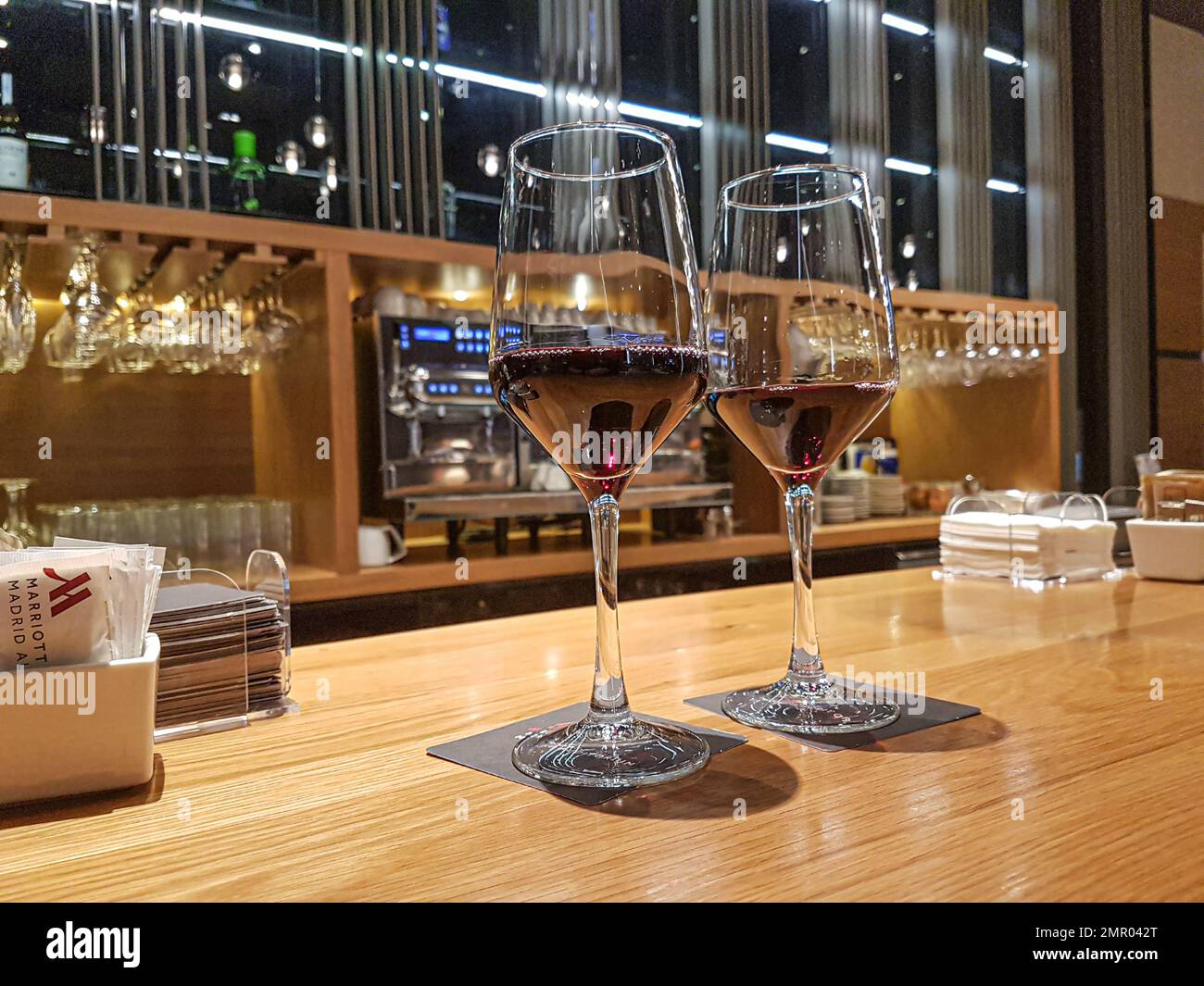 Wine glasses filled with red wine on wooden bar counter from ground ...