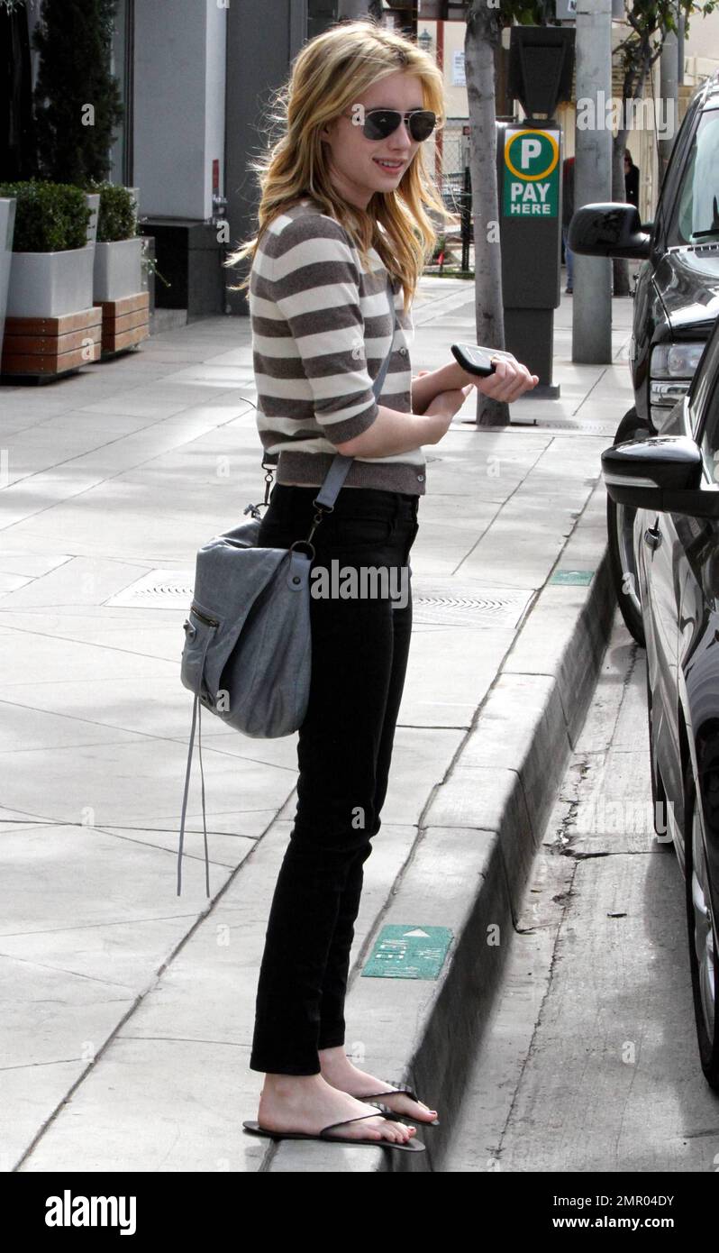 Wearing a striped top, black jeans and salon sandals, actress Emma ...