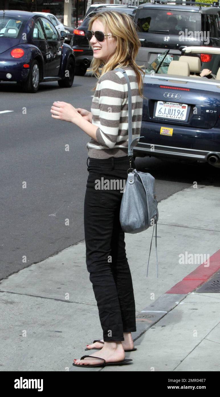 Wearing a striped top, black jeans and salon sandals, actress Emma ...