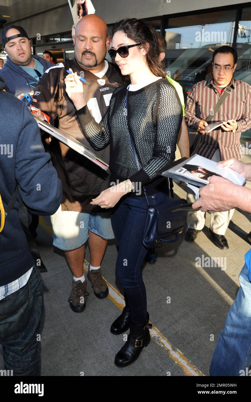 Looking casual in a black sheer sweater over a t shirt paired with ...