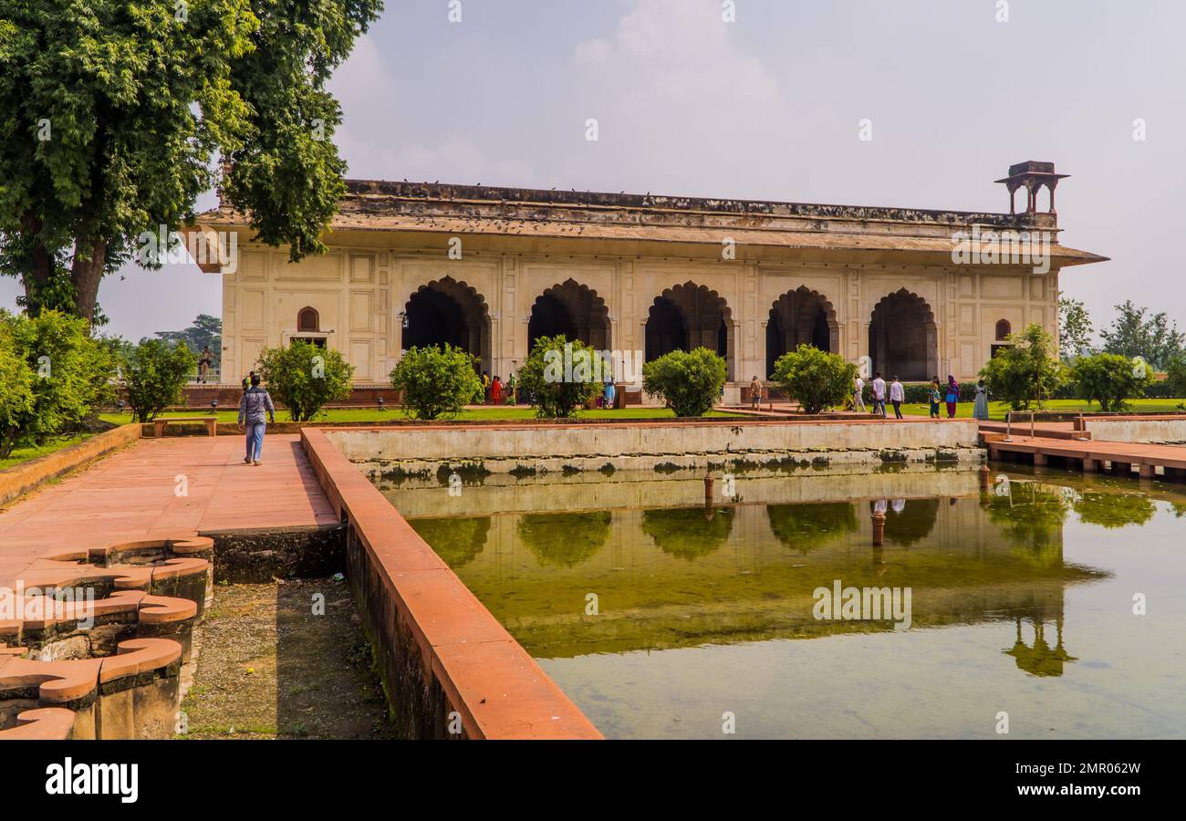 A daytime view of ancient buildings and a small fountain pond inside ...
