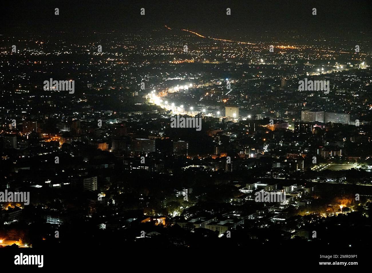 An aerial shot of the lights of a big city at night in total darkness ...
